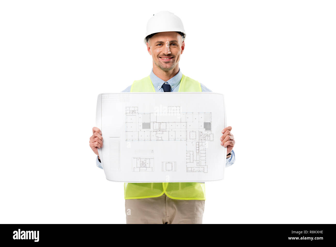 smiling engineer looking at camera and holding blueprint isolated on ...