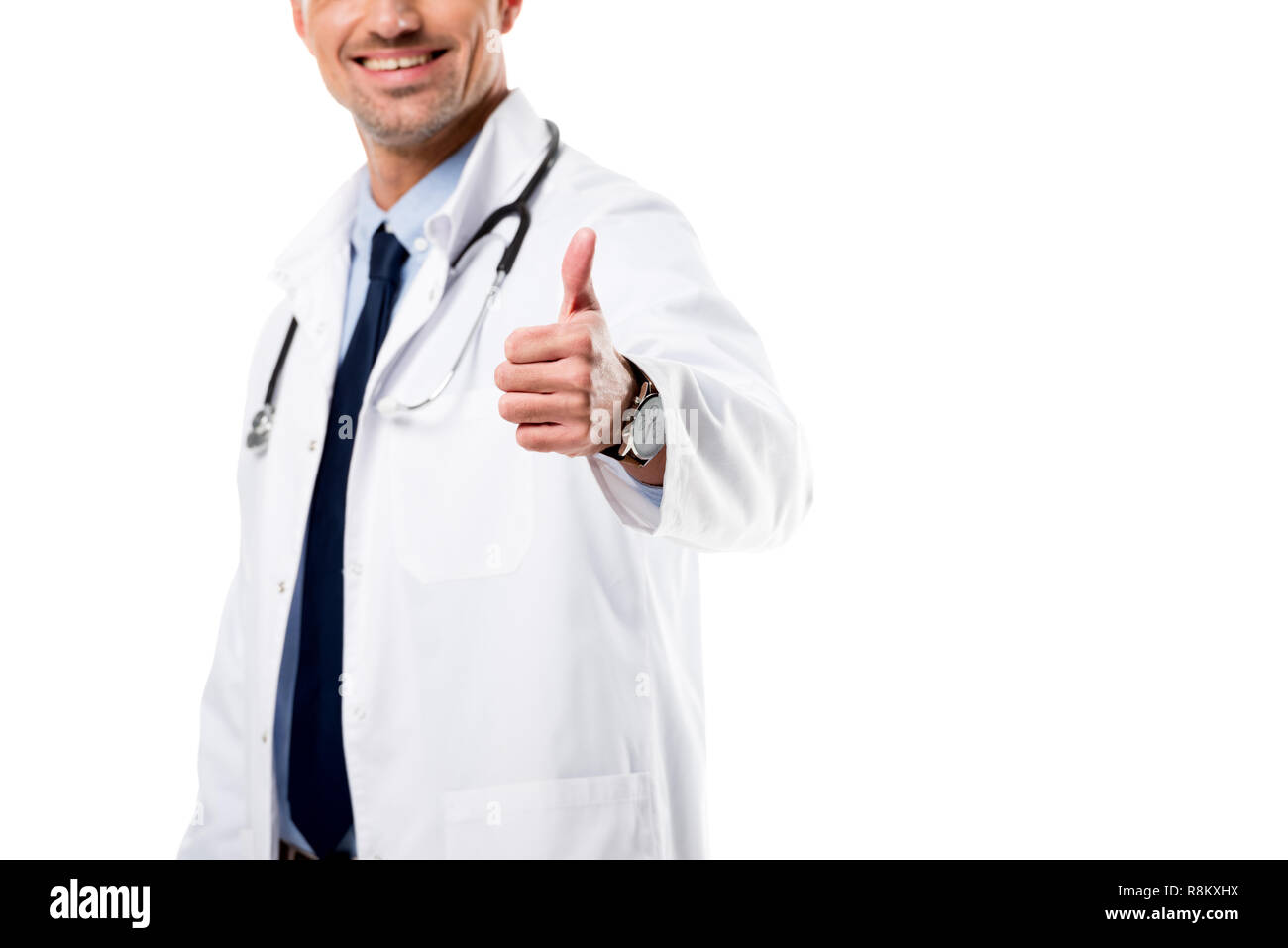 partial view of smiling doctor doing thumb up sign isolated on white ...
