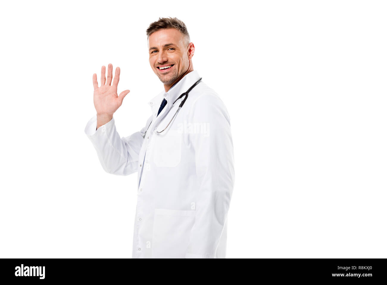 handsome doctor waving and looking at camera isolated on white Stock ...
