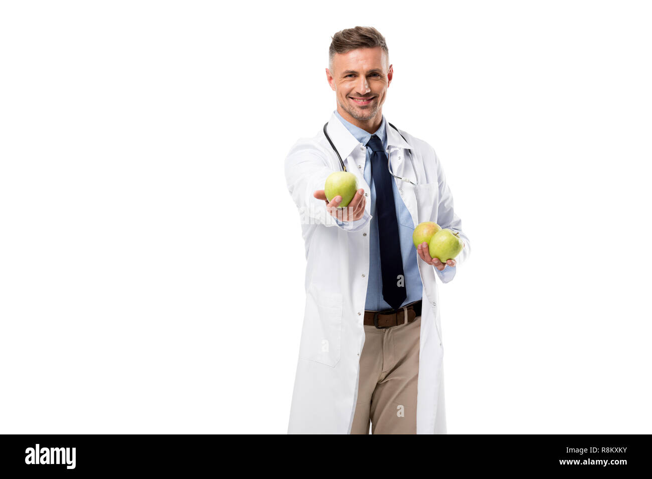 doctor looking at camera and holding fresh apples isolated on white ...