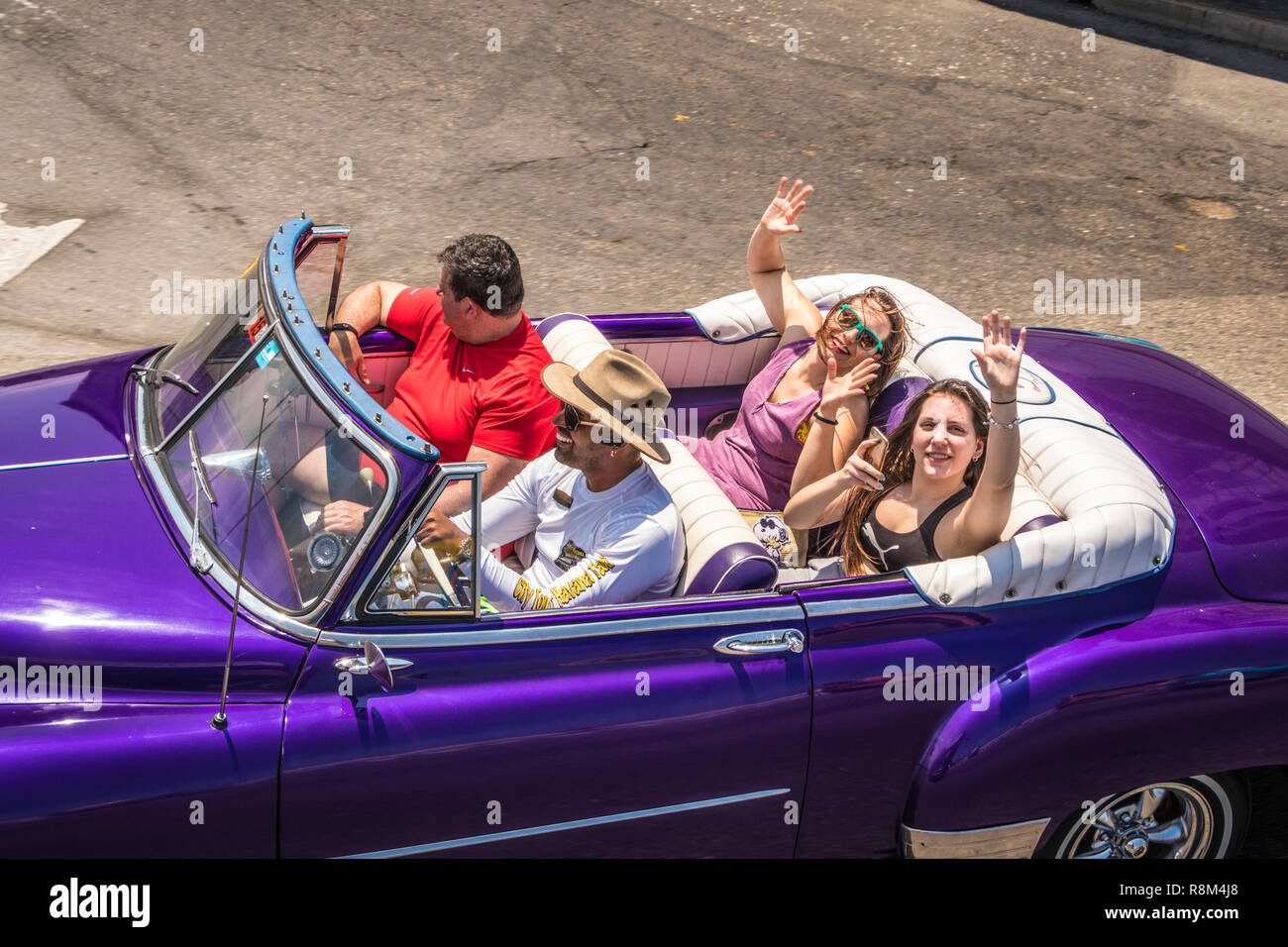 people waving in vintage American 1950s car driving in Havana Cuba ...