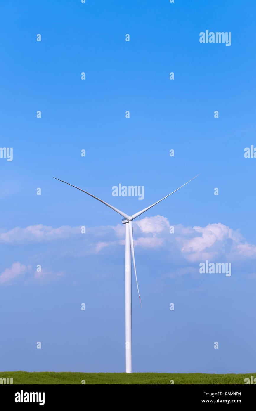 One single windmill turbine on green agricultural field with blue sky ...