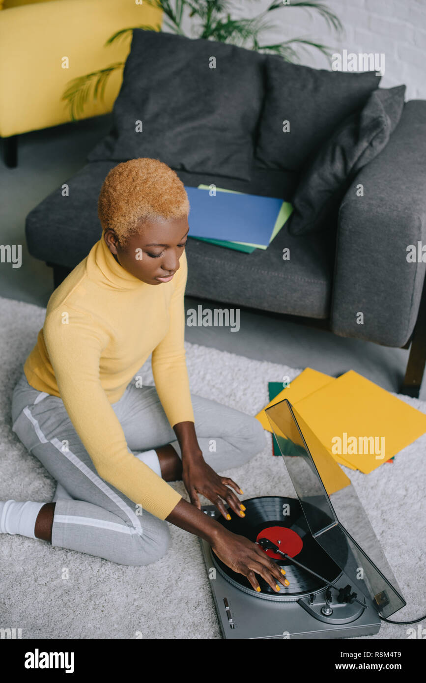attractive african american woman using record player on carpet Stock ...