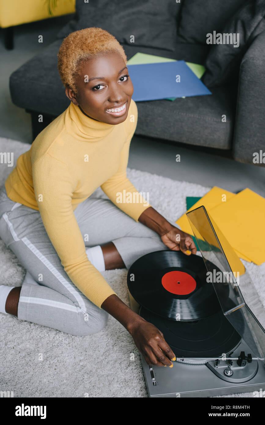 african american woman with short hair holding vinyl record near record ...
