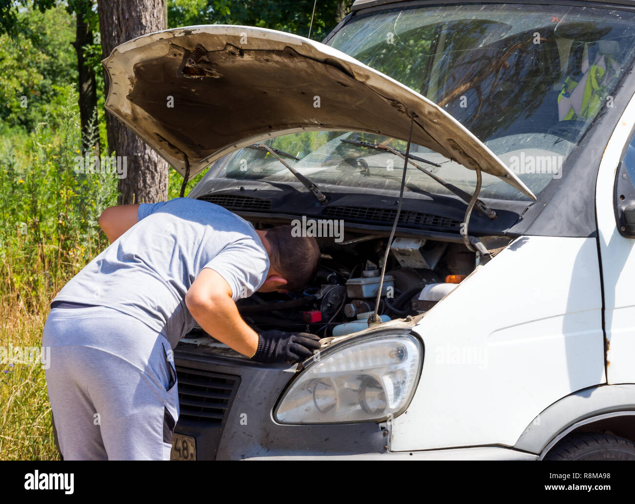 The driver looks under the hood looking for a fault Stock Photo - Alamy