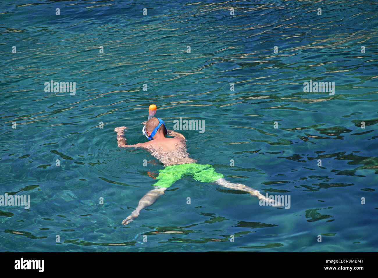 Young man swimming underwater and diving in blue sea water with snorkel ...