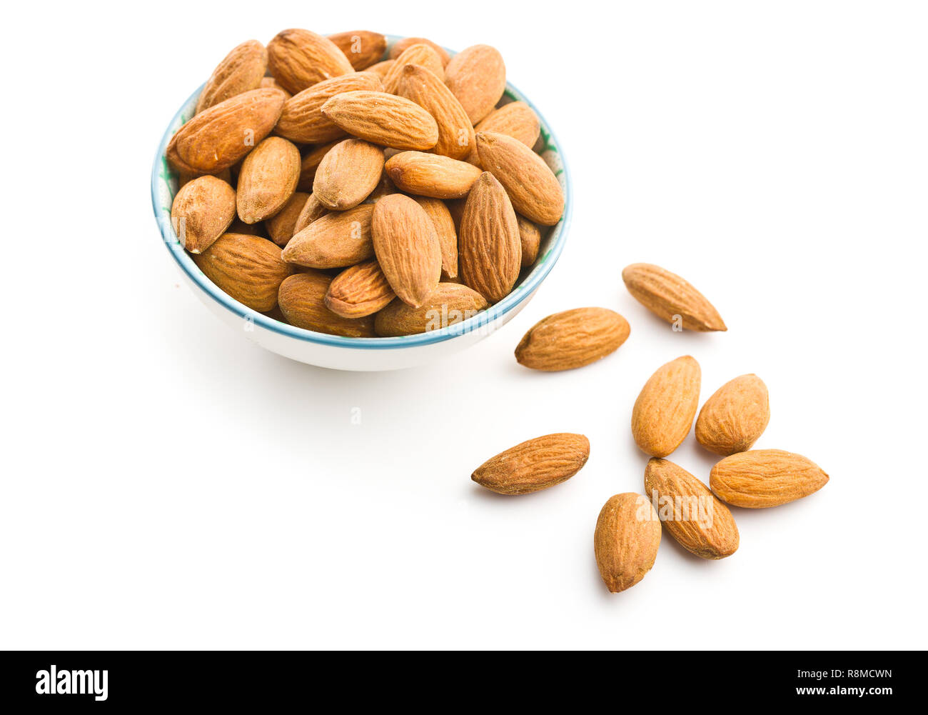 Dried almond nuts in bowl isolated on white background Stock Photo - Alamy