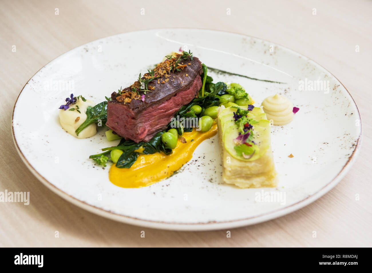 Beef meat with green peas, sweet potato mousse, roasted spinach and ...