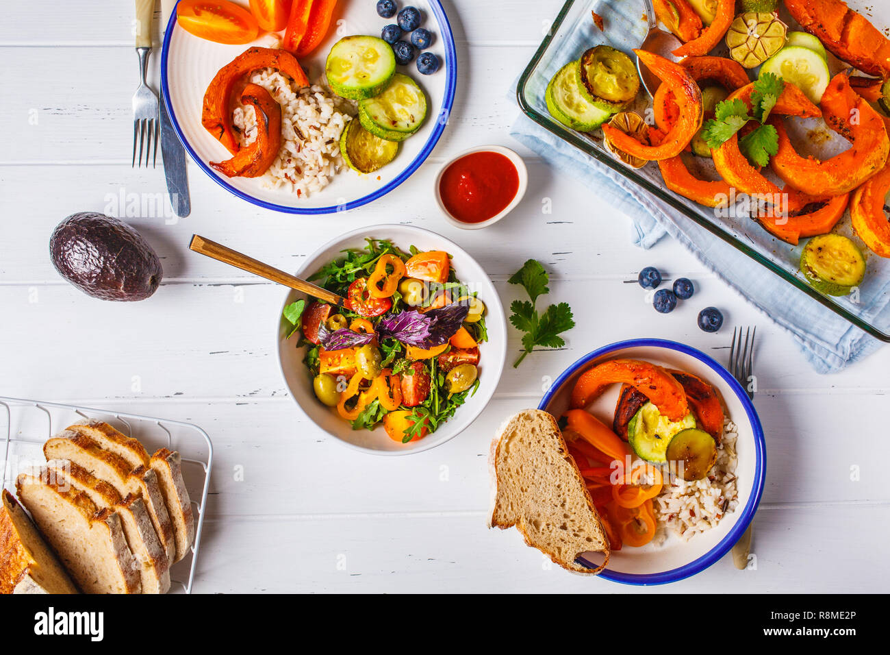 Vegan lunch table top view. Baked vegetables, fresh salad, berries ...
