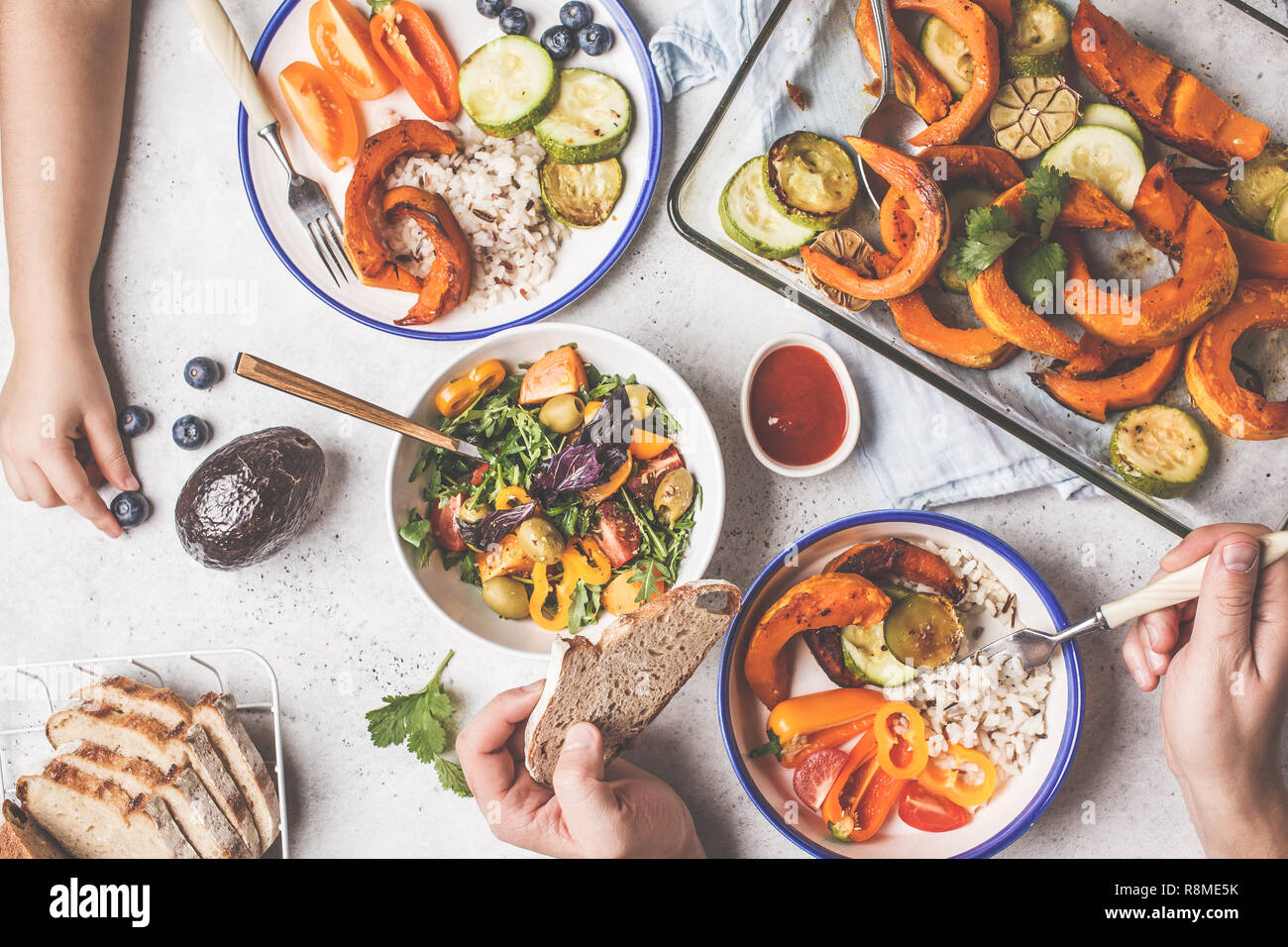 Flat lay of family hands eating healthy food. Vegan lunch table top ...