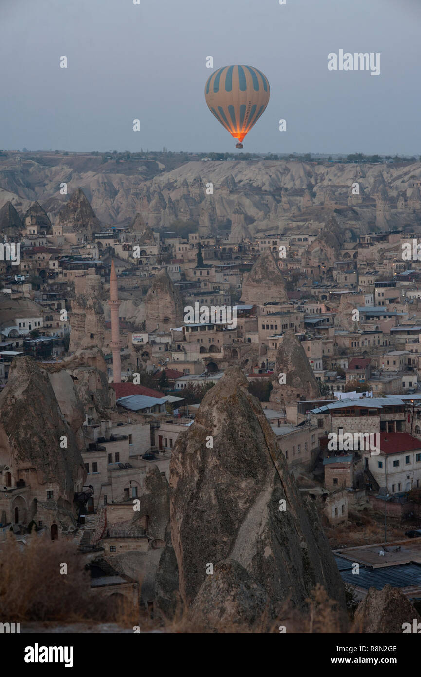 A hot air balloon seen flying over Goreme village in Cappadocia Turkey ...