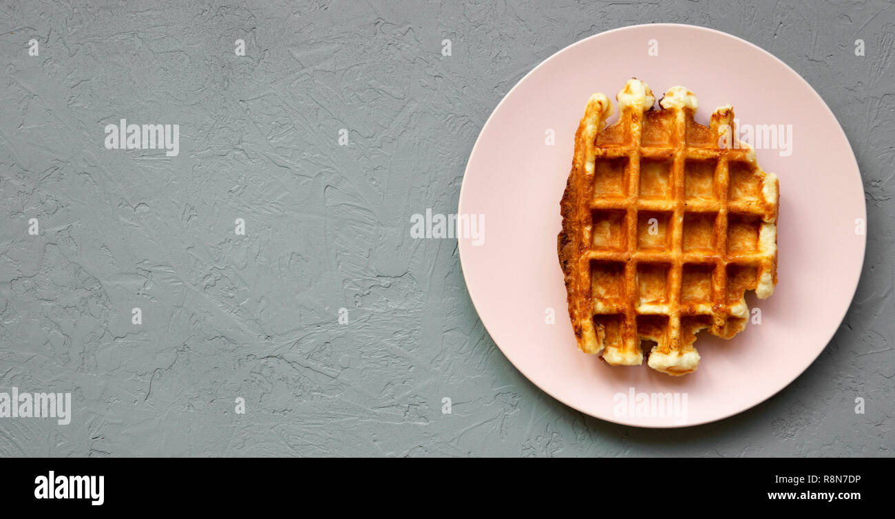 Traditional belgian waffle on pink plate on concrete background ...