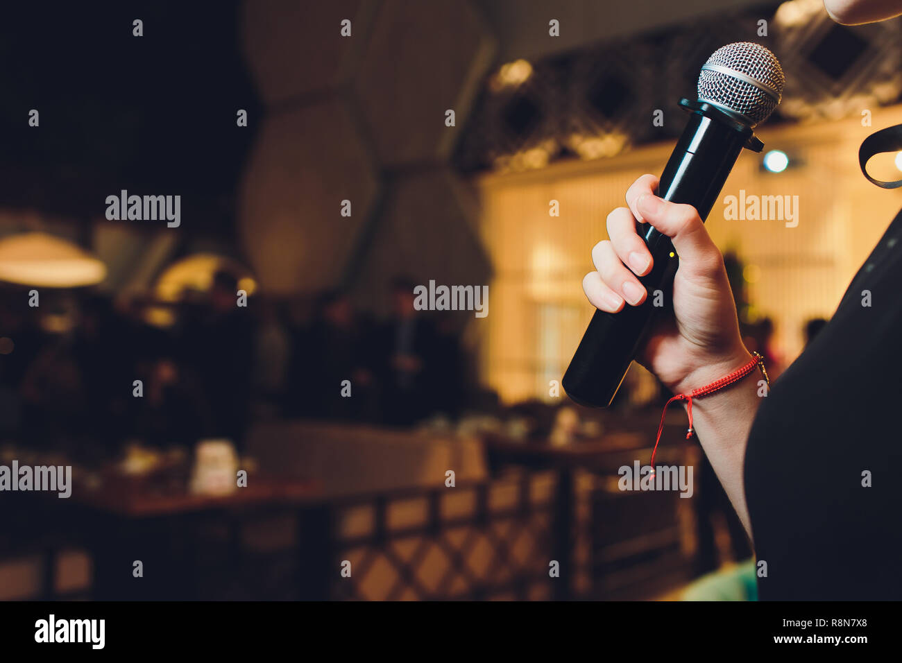 Close up male hand holding microphone. in the interior of the bar Stock ...