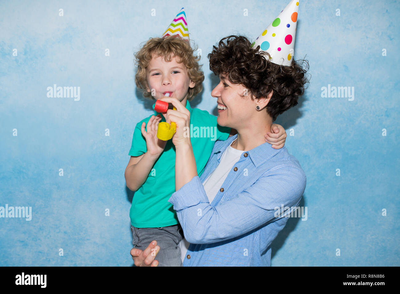 Young woman blowing party horn hi-res stock photography and images - Alamy