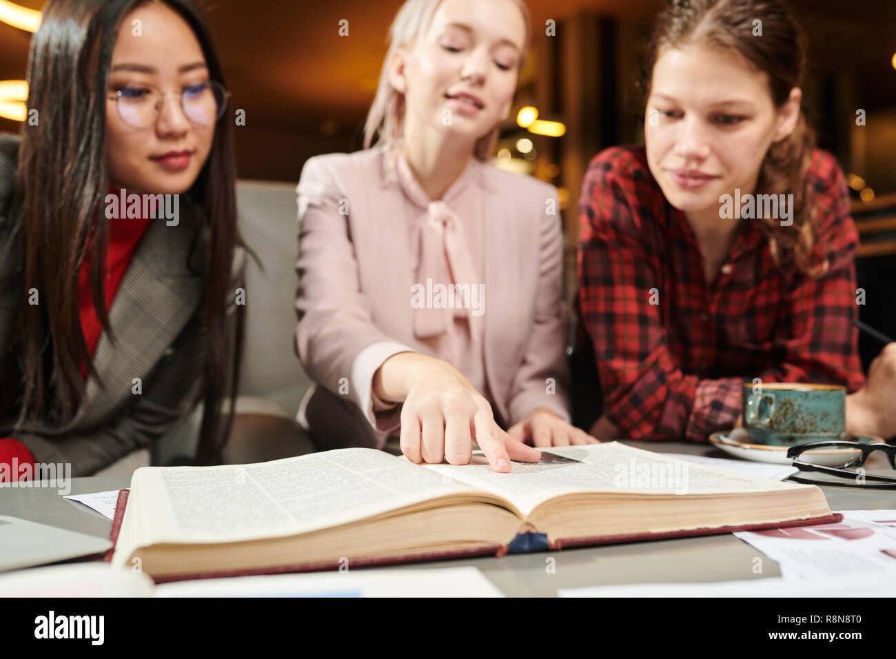 Students reading a book Stock Photo - Alamy