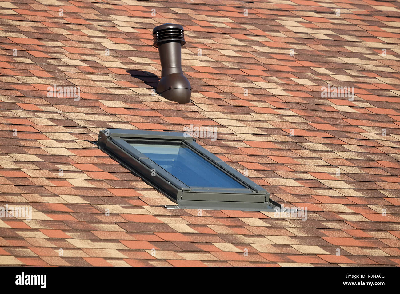 Roof window and ventilation tube on residential house covered with ...
