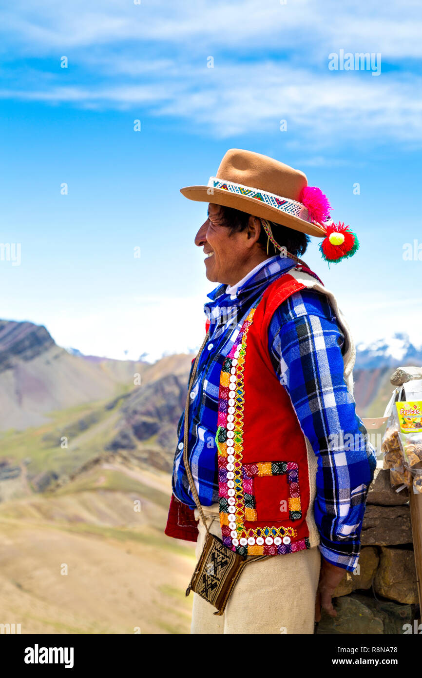 Portrait of a smiling Peruvian man standing in the Rainbow mountains ...