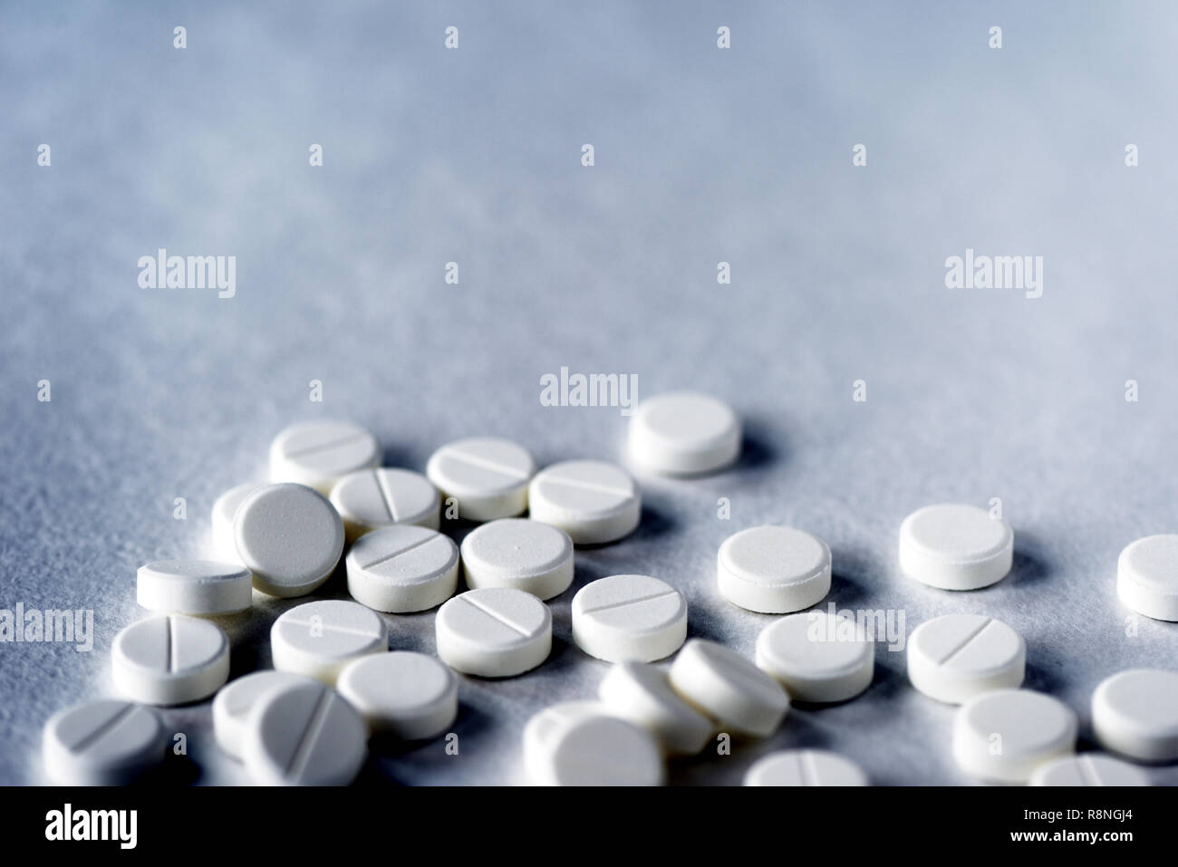 White pills tablets on a gray surface close up Stock Photo - Alamy