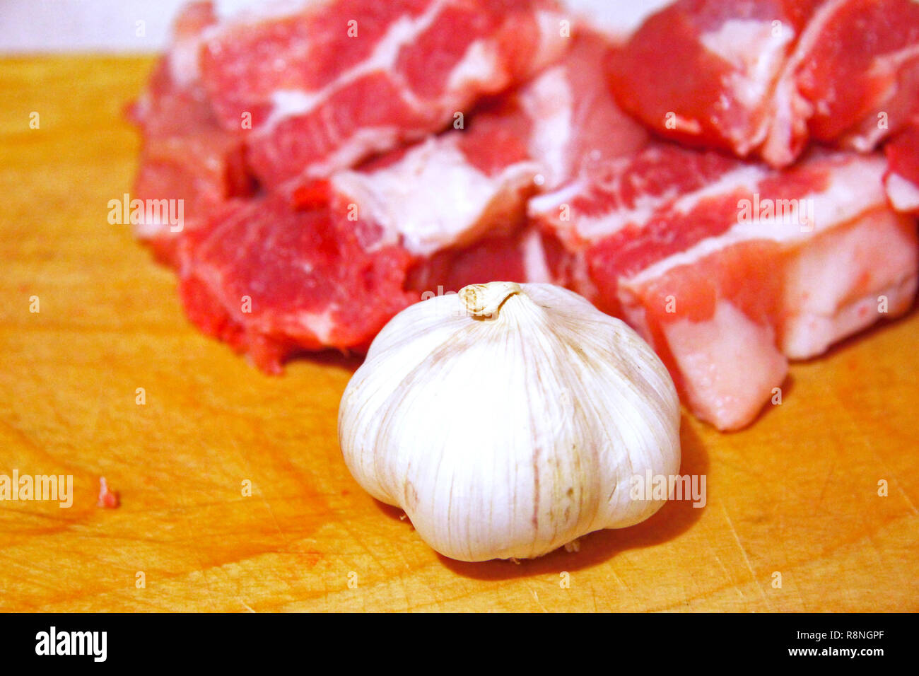 Fresh meat and fresh garlic laying on the kitchen desk Stock Photo - Alamy