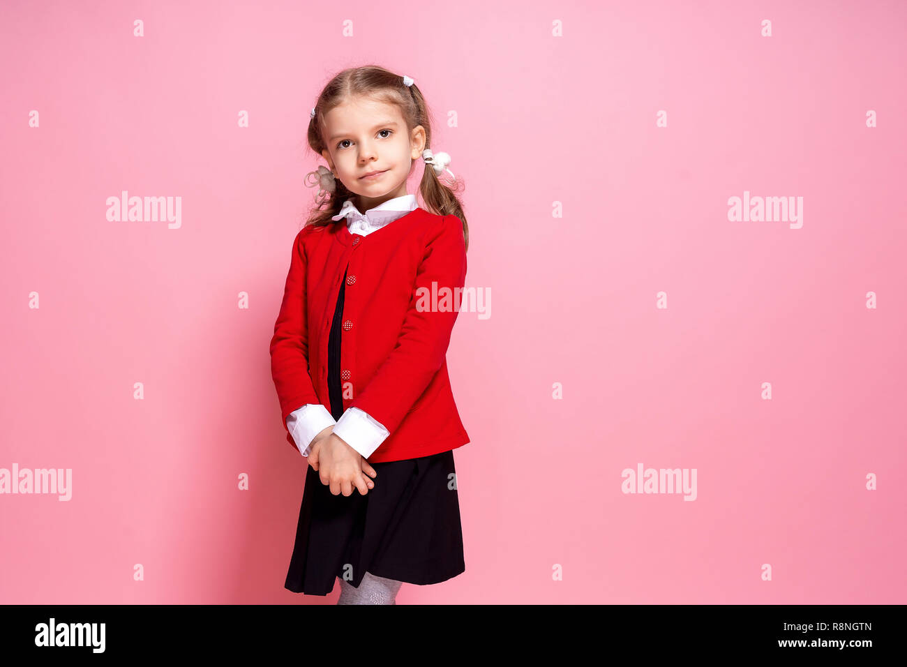 Adorable little girl in red school jacket and black dress looking at ...
