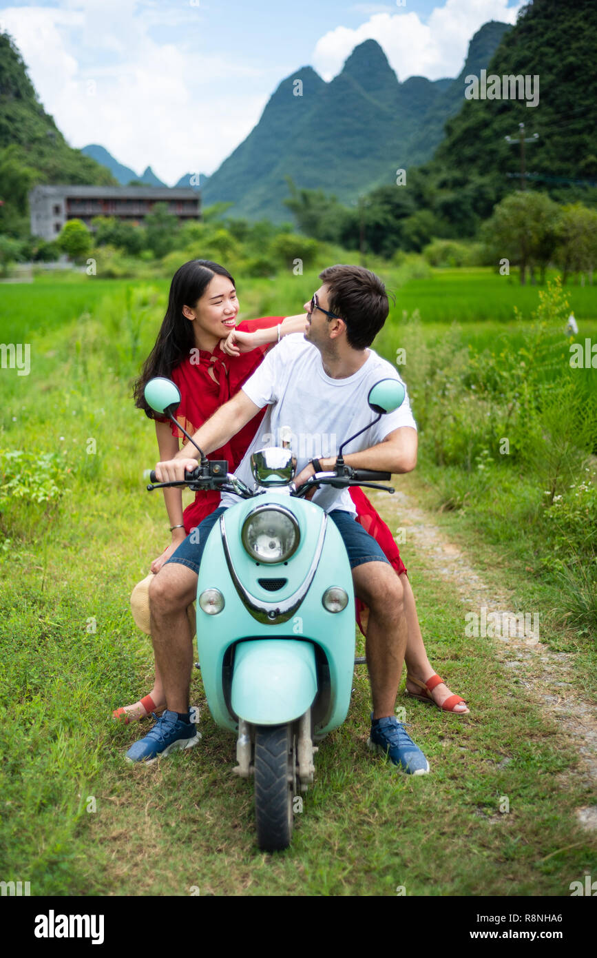 Couple having fun on motorbike around rice fields of Yangshuo, China ...