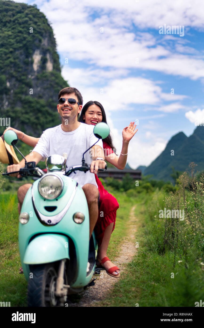 Couple having fun on motorbike around rice fields of Yangshuo, China ...