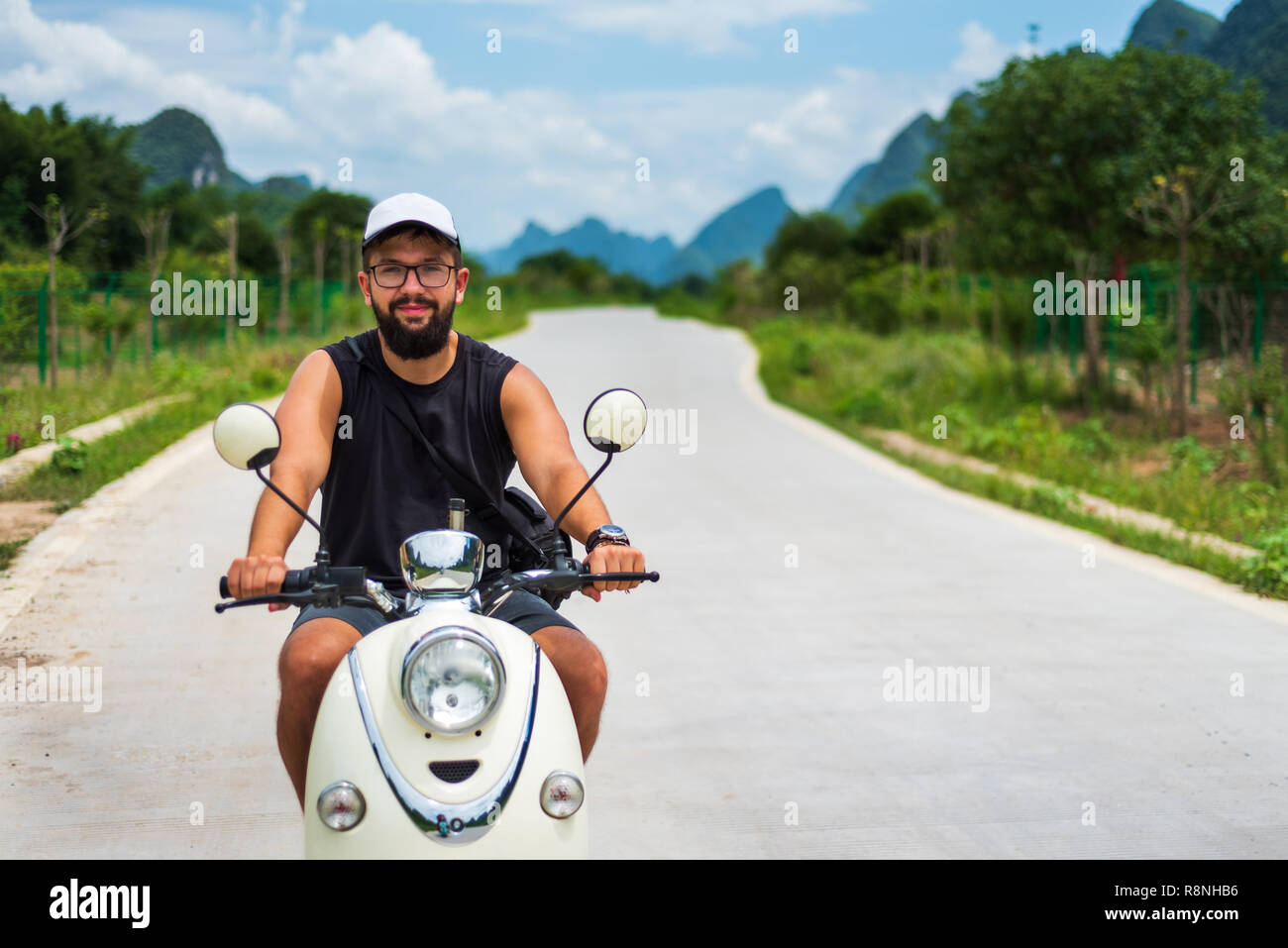 Male traveler riding motorbike on Asian trip Stock Photo - Alamy
