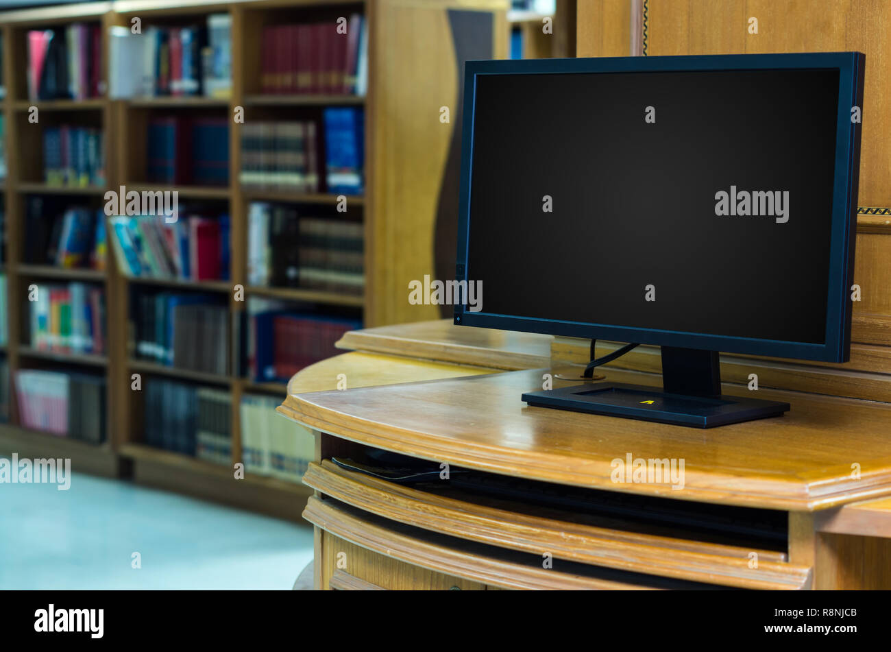 Computer monitor on the desk in library with photo store blur ...