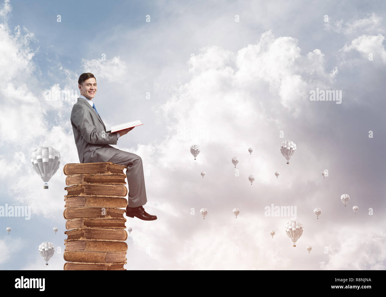 Man student reading book and aerostats flying around in air Stock Photo ...
