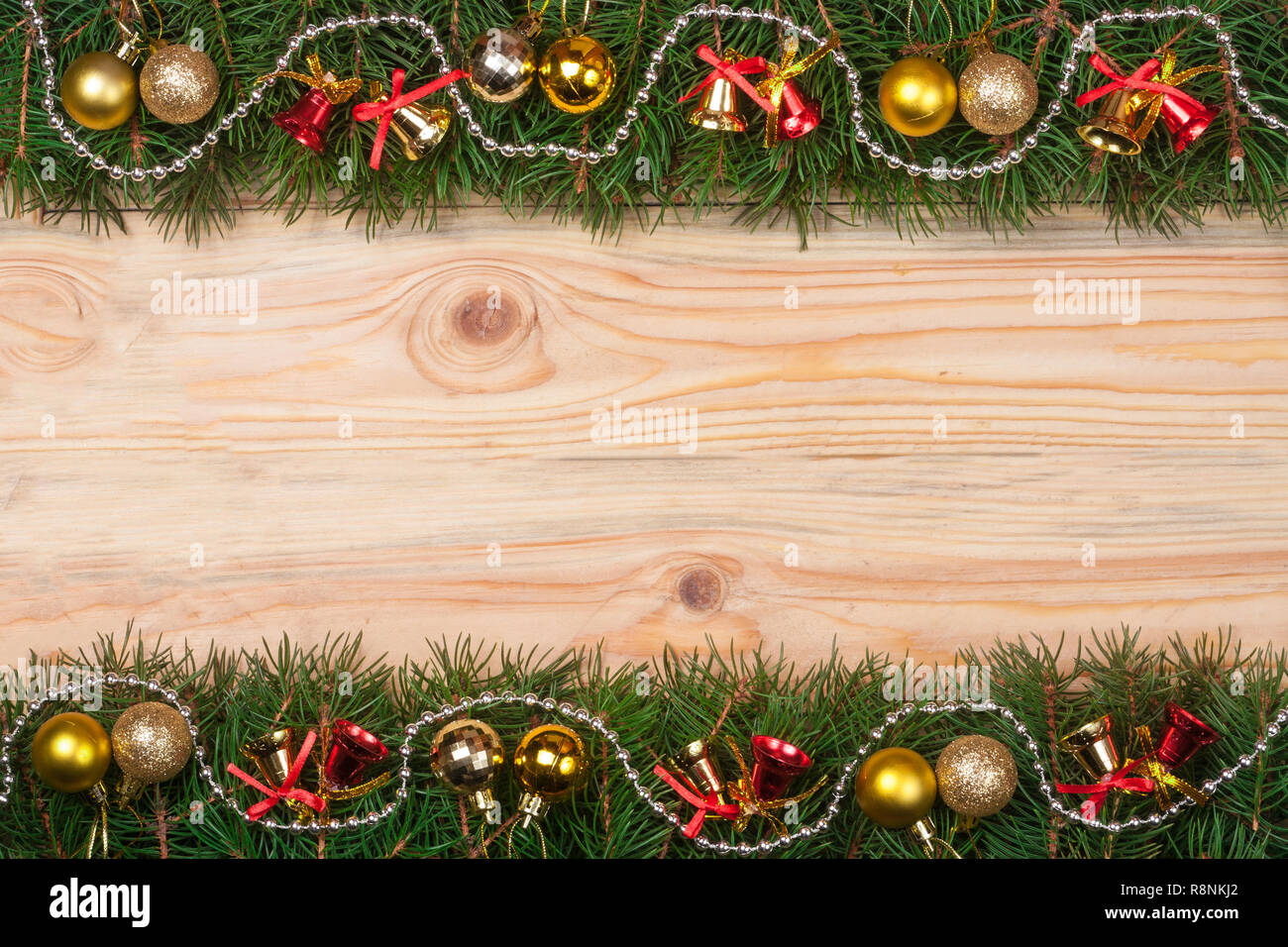 Christmas frame made of fir branches decorated with bells beads and ...