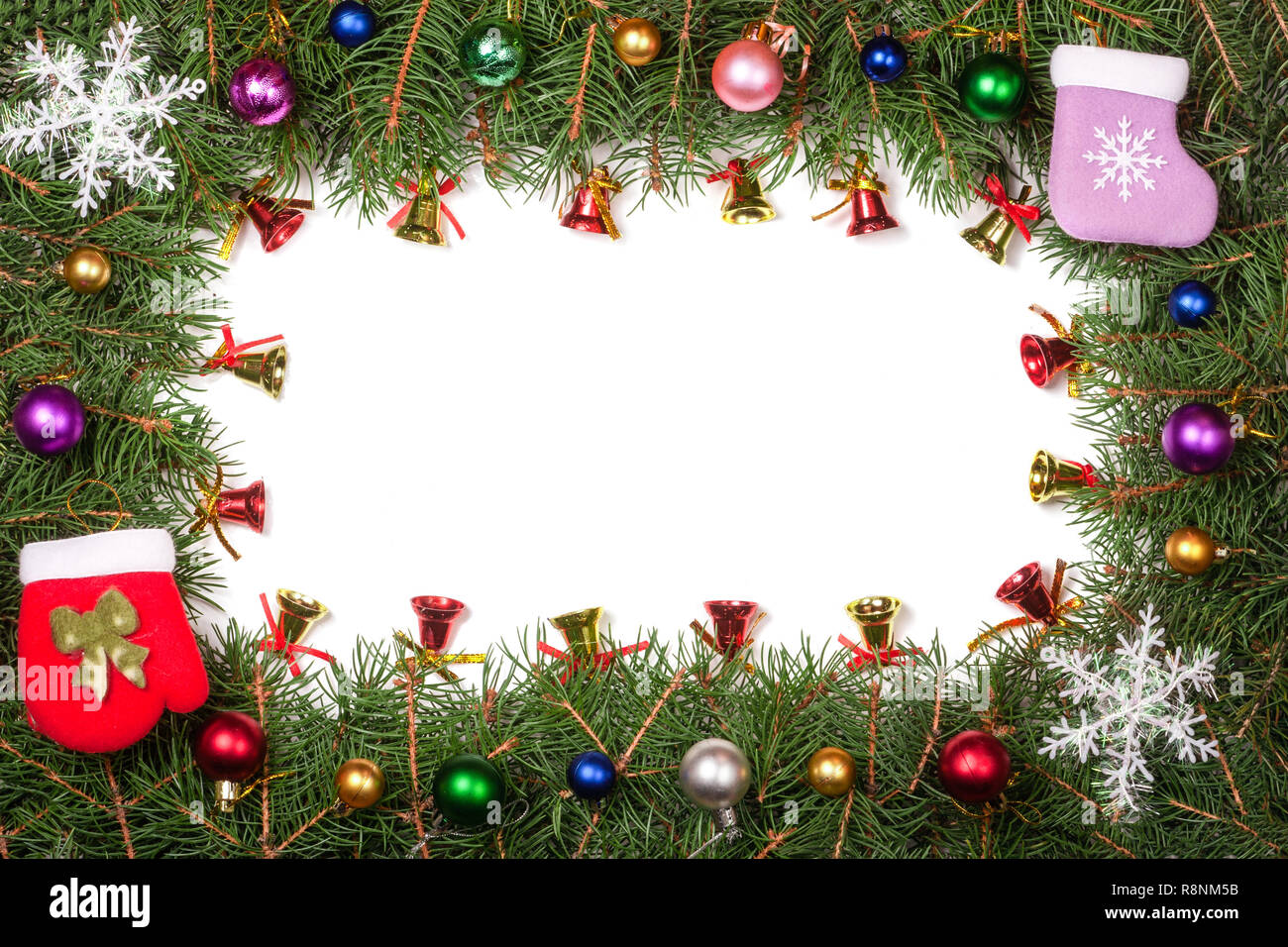 Christmas frame made of fir branches decorated with balls and bells ...