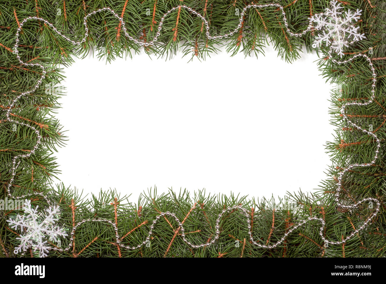 Christmas frame made of fir branches decorated with beads and snowflake ...