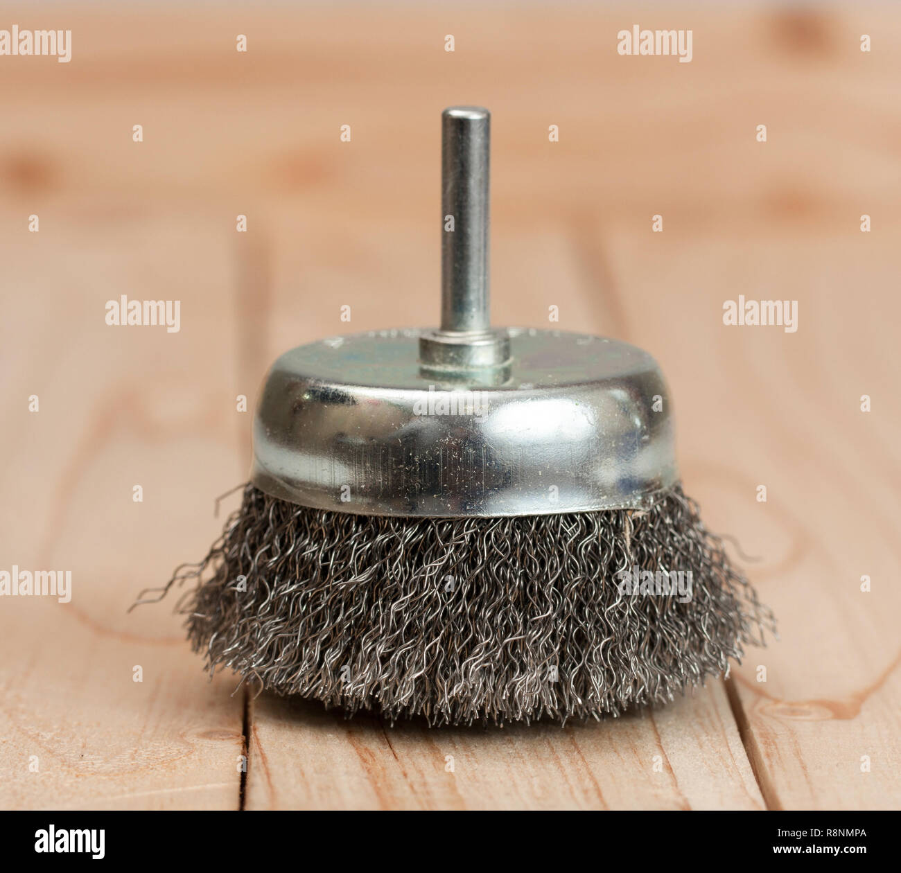 metal brush on a drill to remove rust on a light wooden background ...