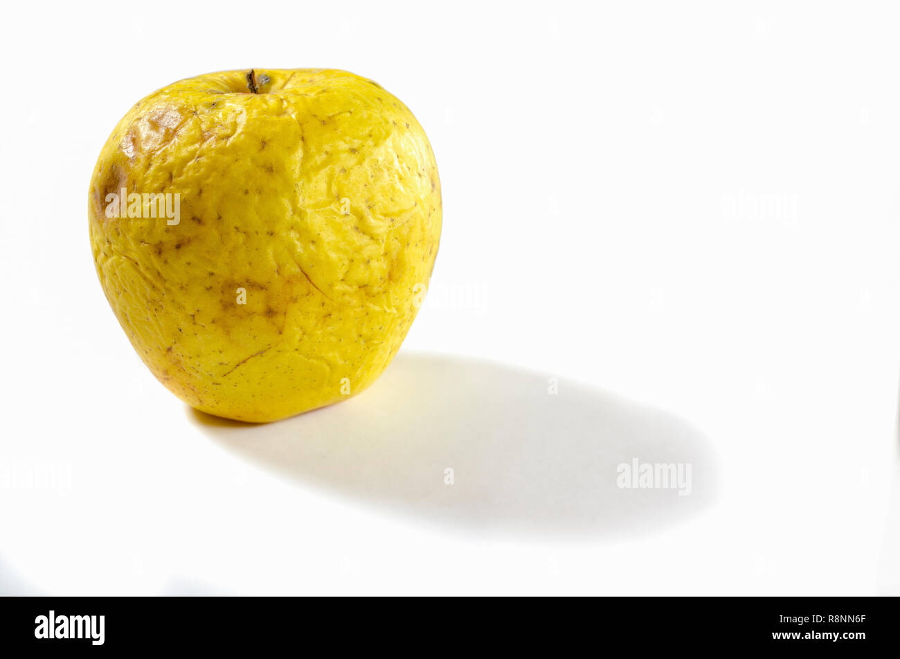An old wrinkled apple lying on a white background. isolated Stock Photo ...