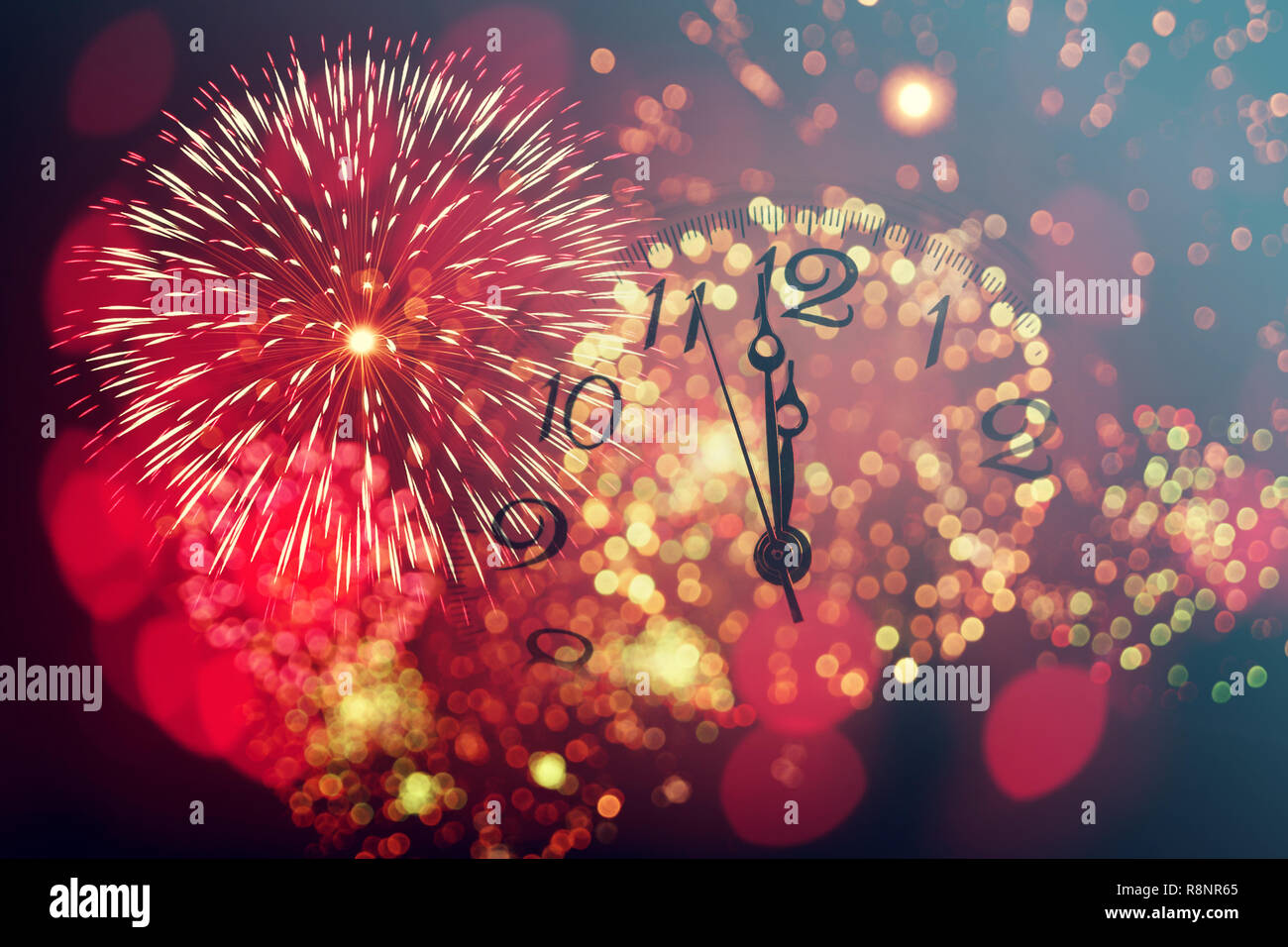 New Year's at midnight - Old clock with fireworks and holiday lights ...
