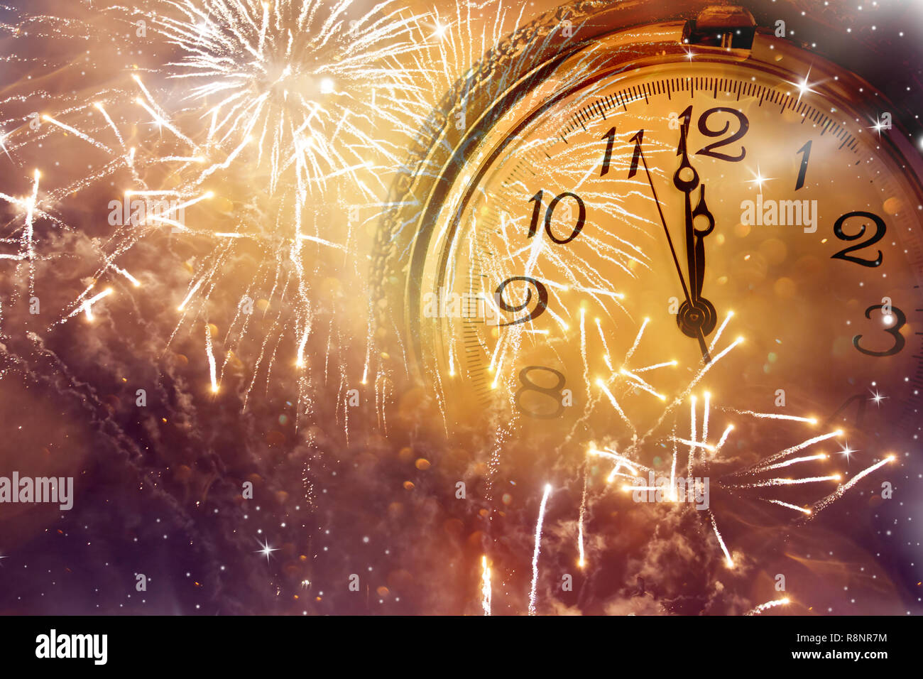 New Year's at midnight - Old clock with fireworks and holiday lights ...