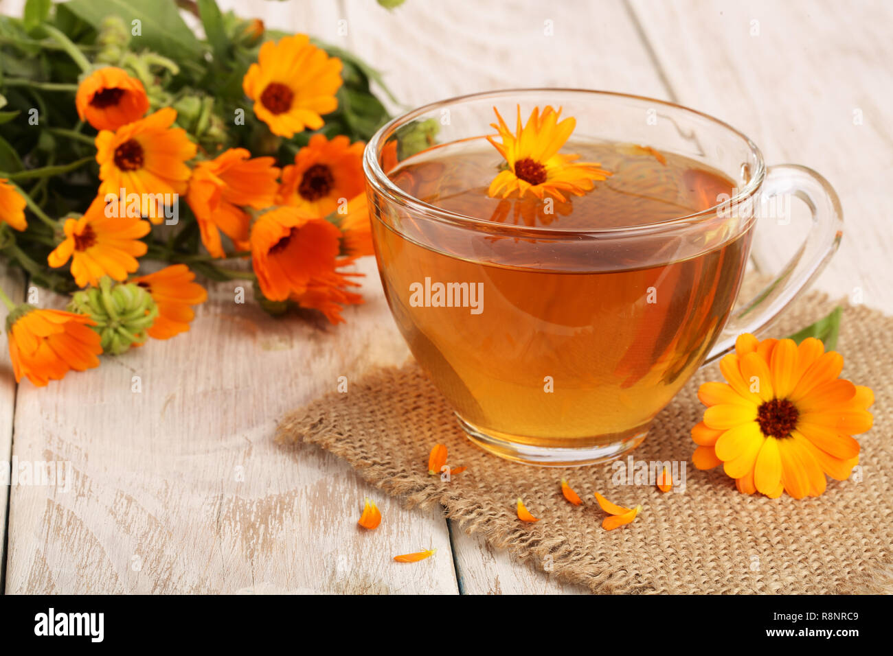 Calendula tea with fresh flowers on white wooden background Stock Photo ...
