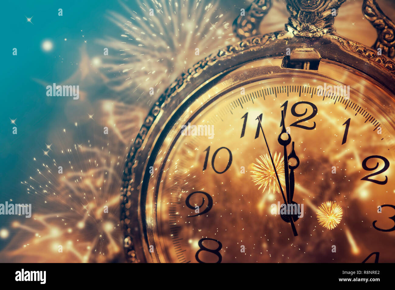 New Year's at midnight - Old clock with fireworks and holiday lights ...