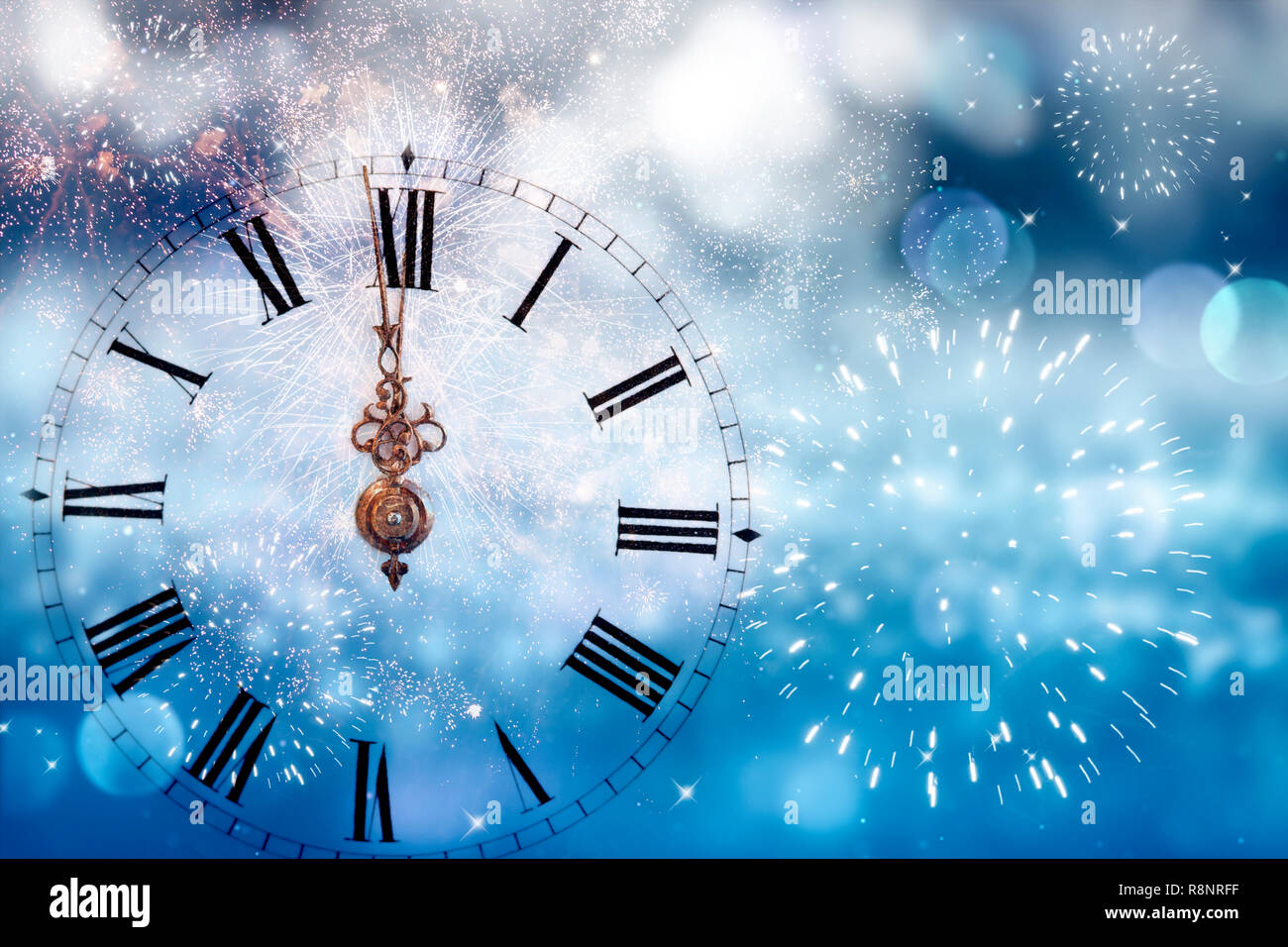 New Year's at midnight - Old clock with fireworks and holiday lights ...