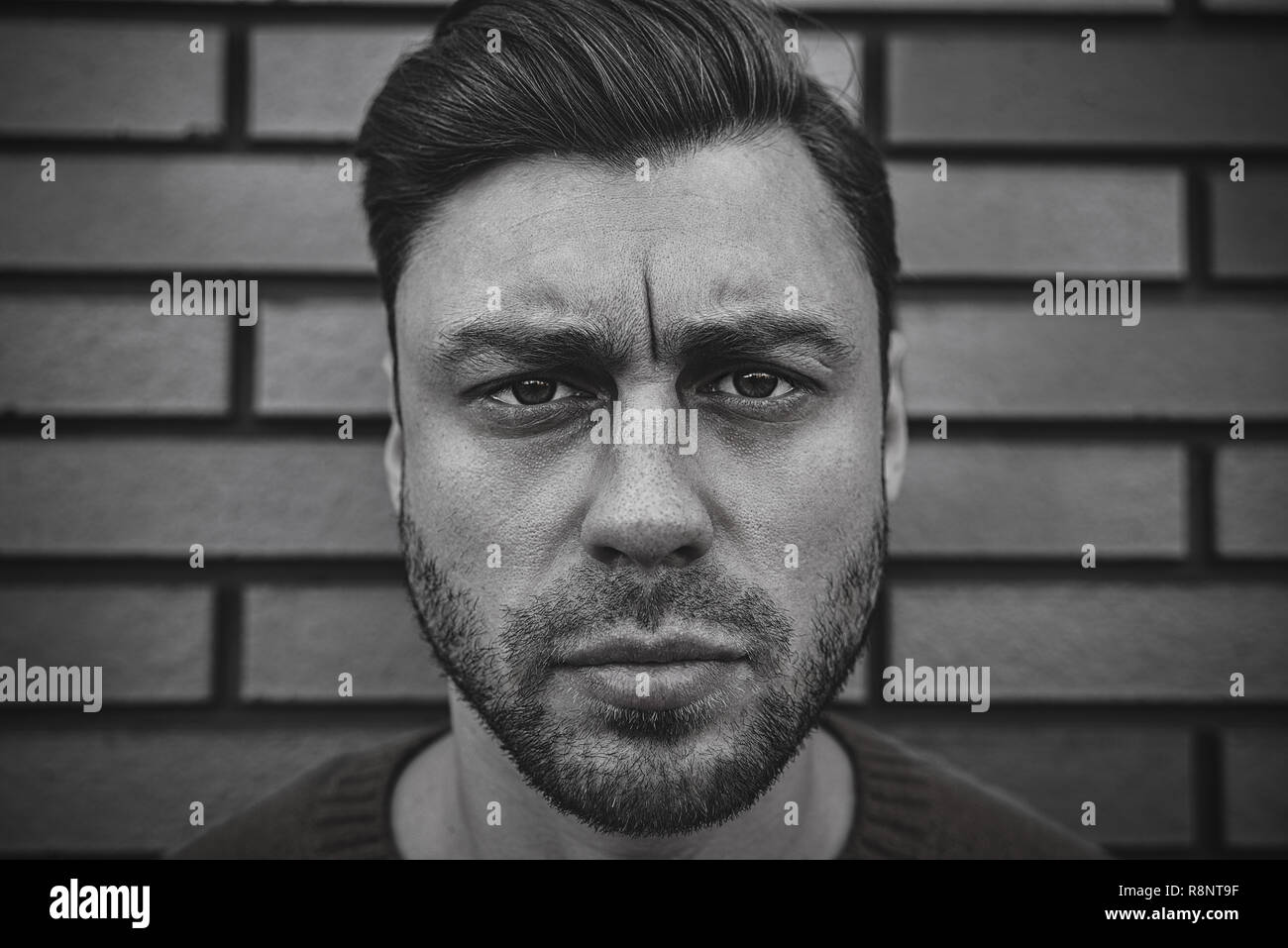 Portrait of a caucasian handsome man that is seriously frowning ...