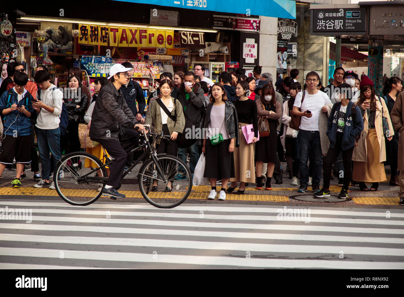 Japanese pedestrians waiting to cross a road in the Shibuya area of ...