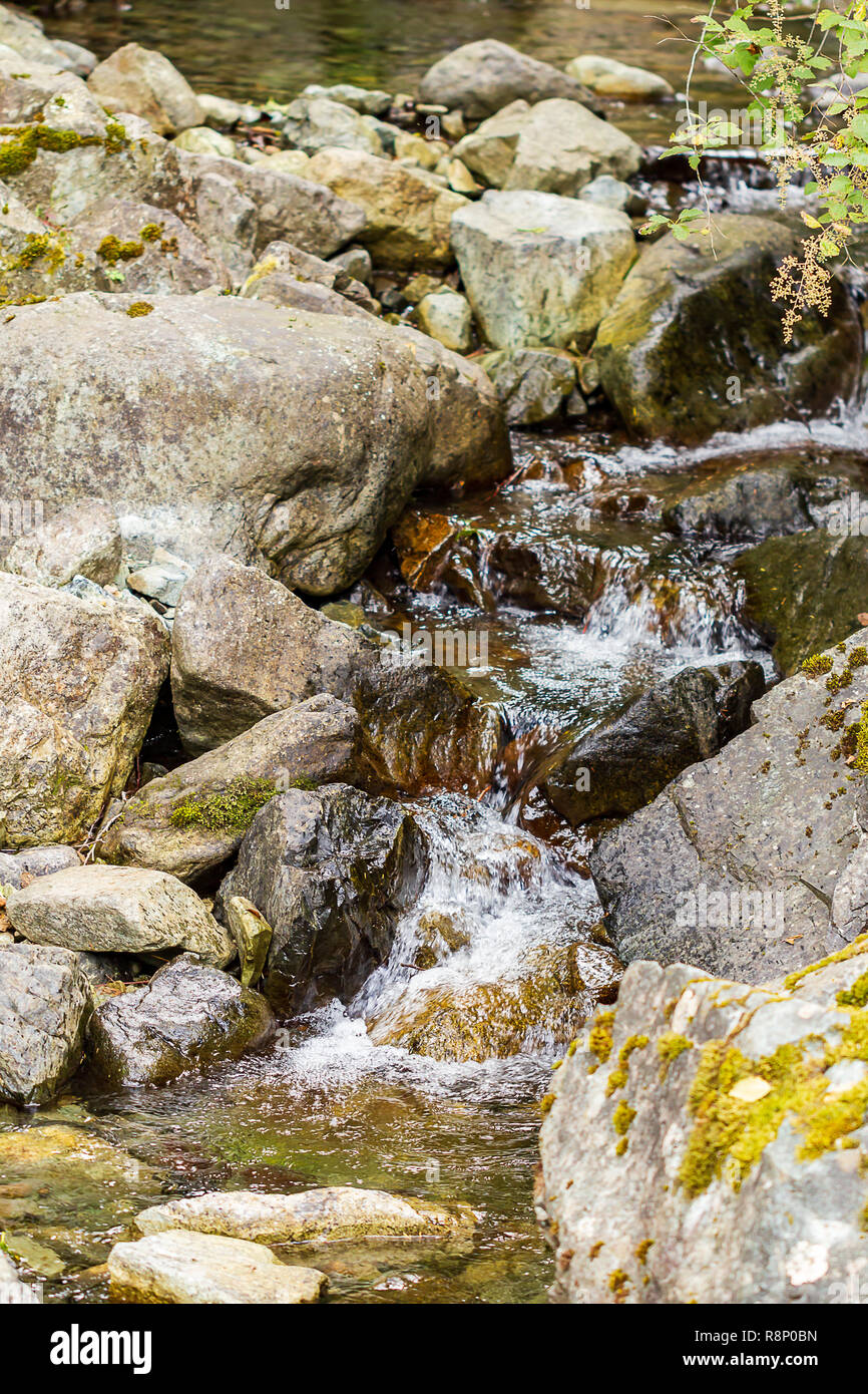 water falling over large rocks and small pebbles Stock Photo - Alamy