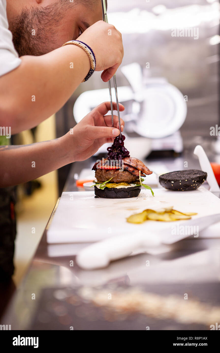 Chef performs how to make proper buger. Delicious food Stock Photo - Alamy