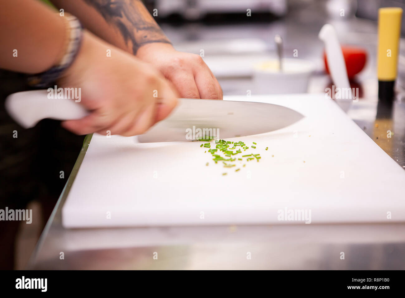 Chef slicing greenery on white cutting table. Fresh vegetables Stock ...