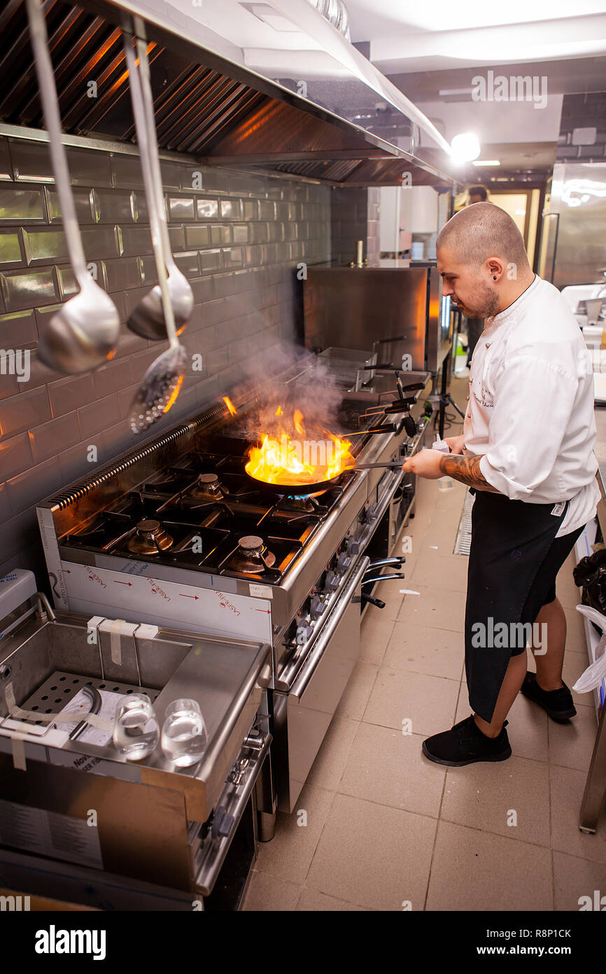 Chef cooking and doing flambe on food in restaurant kitchen , Great ...