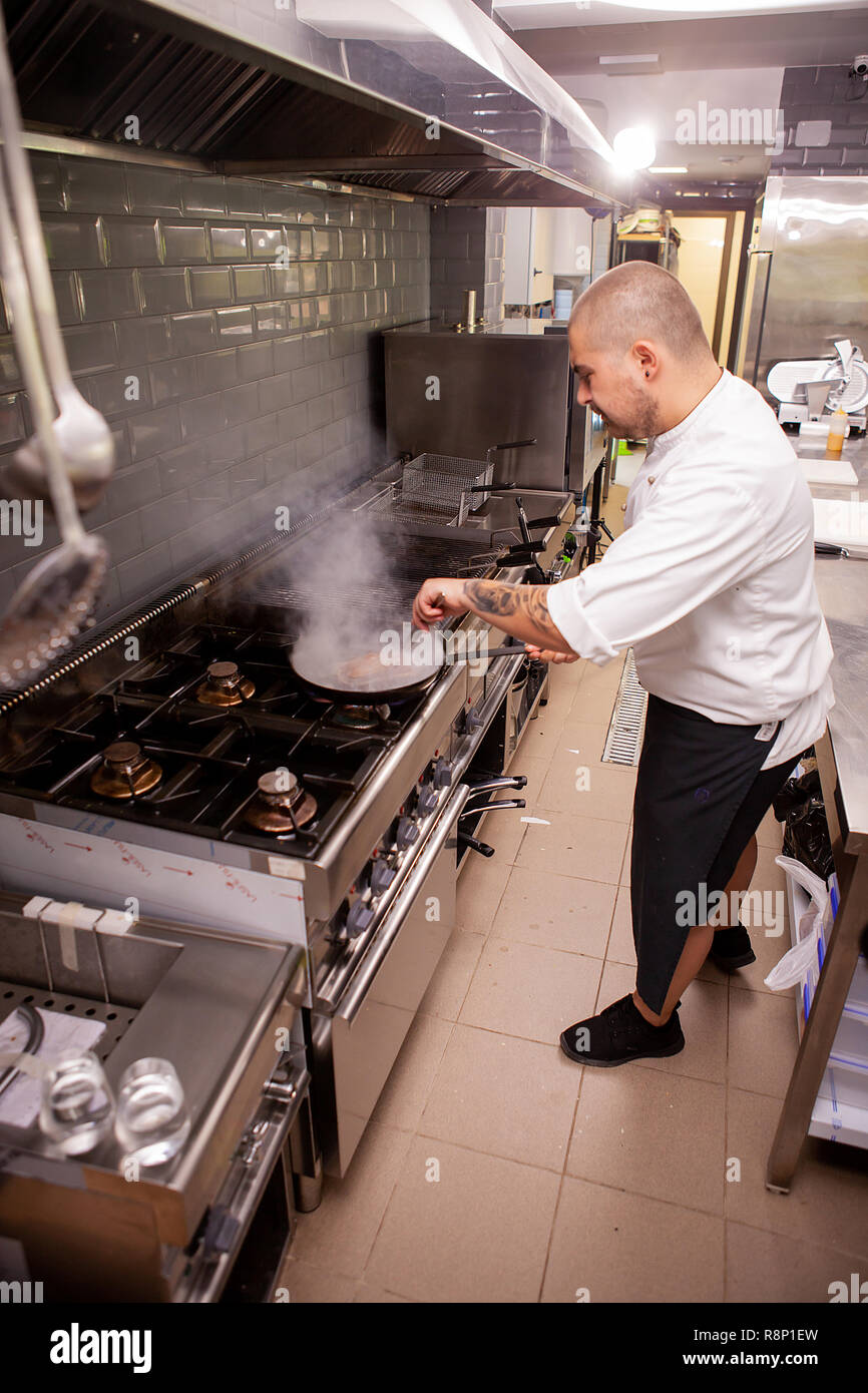 Chef cooking with flame on his restaurant kitchen.Skilled cook Stock ...