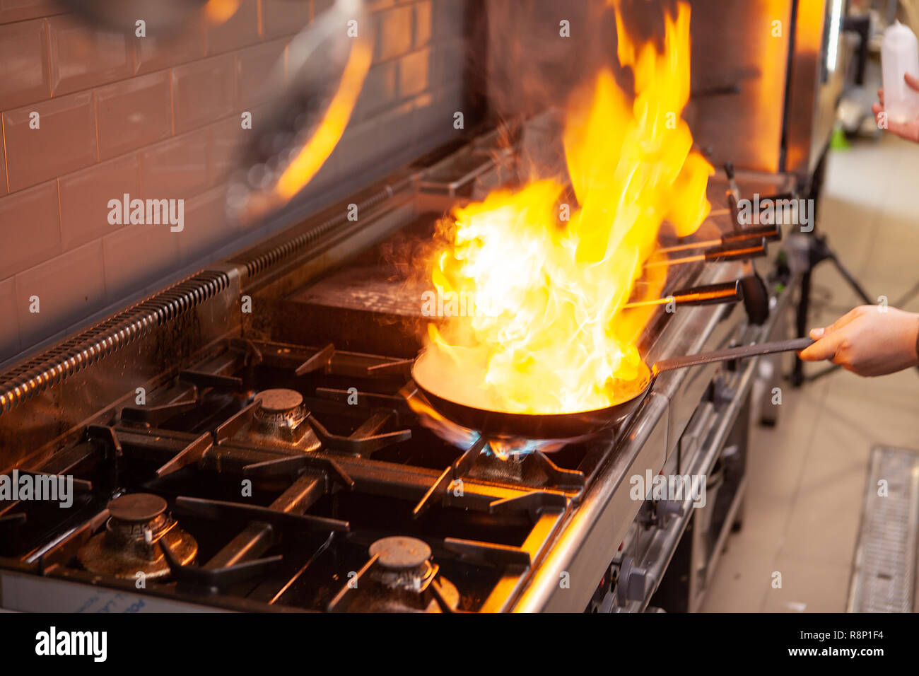 Chef cooking with flame on his restaurant kitchen.Skilled cook Stock ...