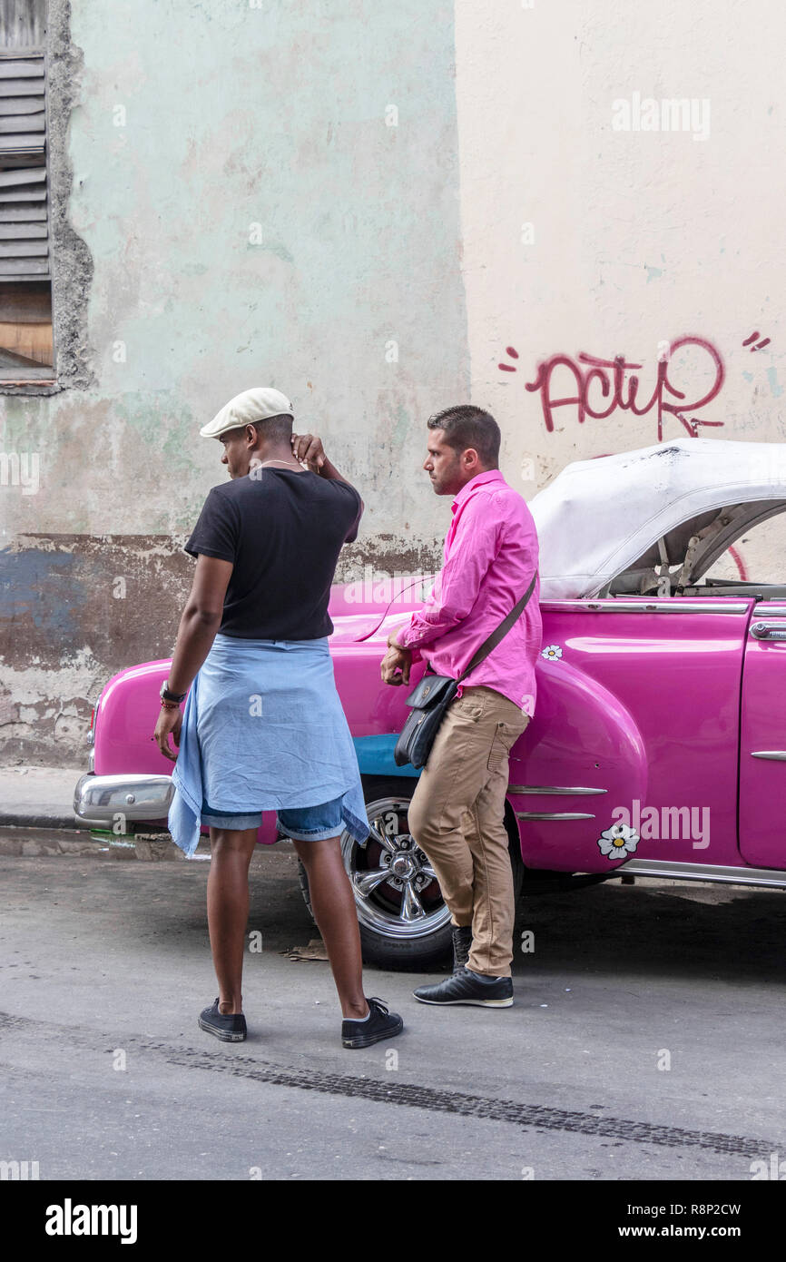 classic pink American car broken down and being fixed by mechanic in ...
