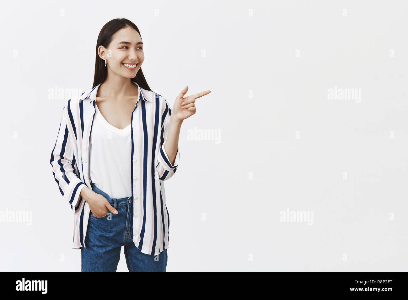 Indoor shot of attractive beautiful european female employee pointing ...
