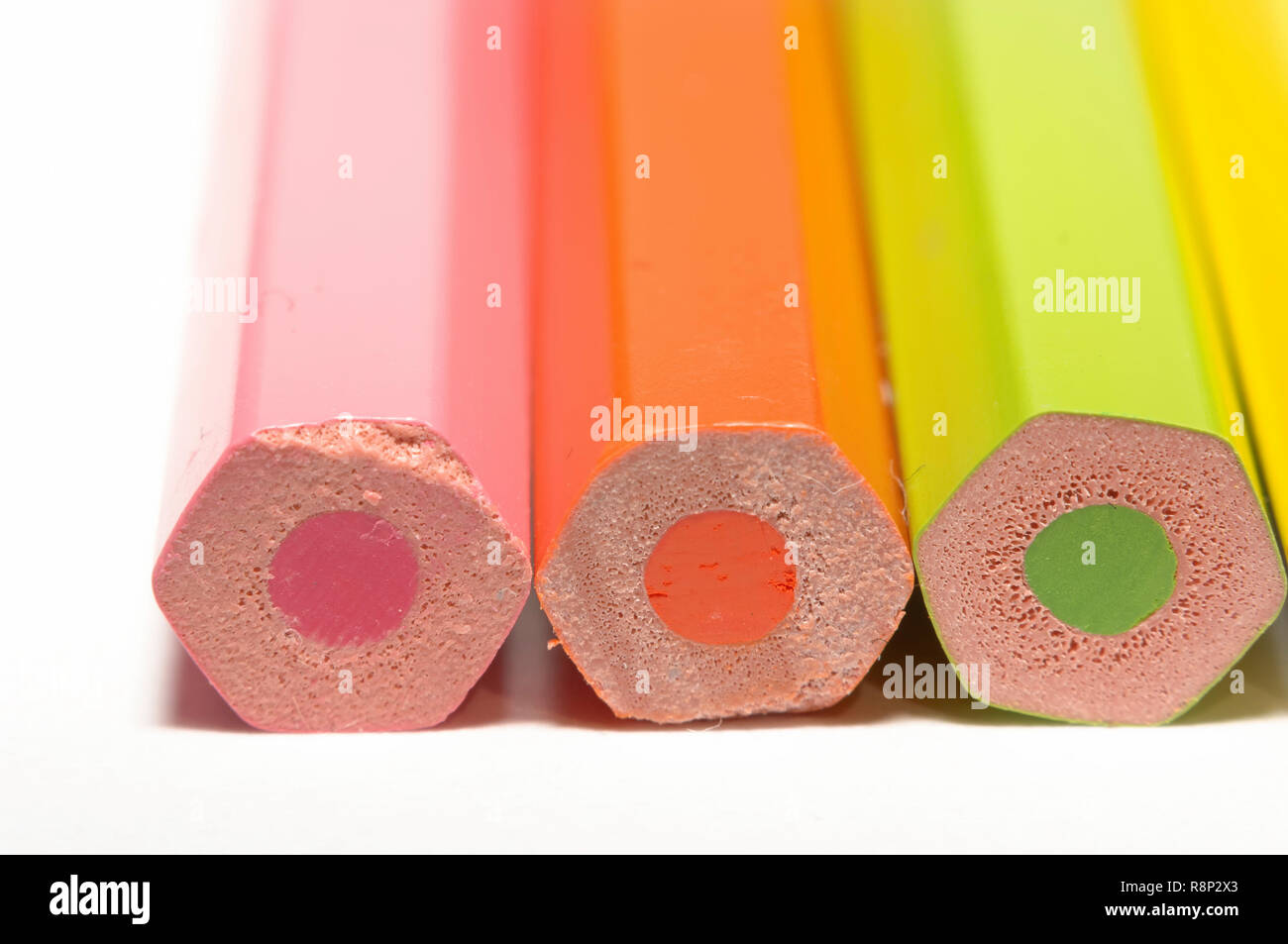 Macro of pink orange green yellow color pencils, all lined up, isolated ...